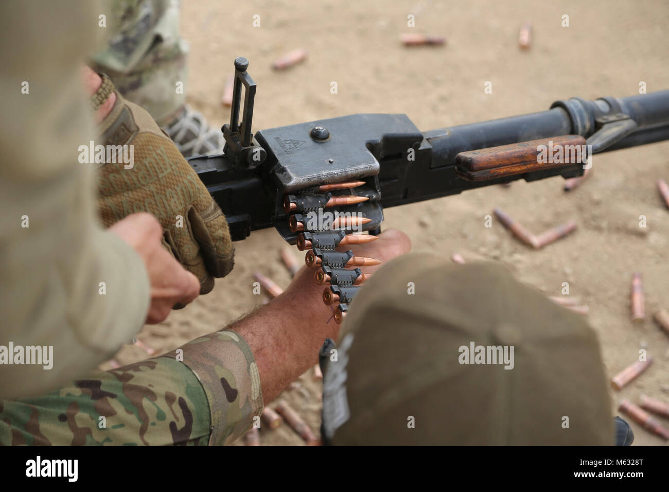 An Italian coalition member tells an Iraqi soldier to pull the bolt to ...