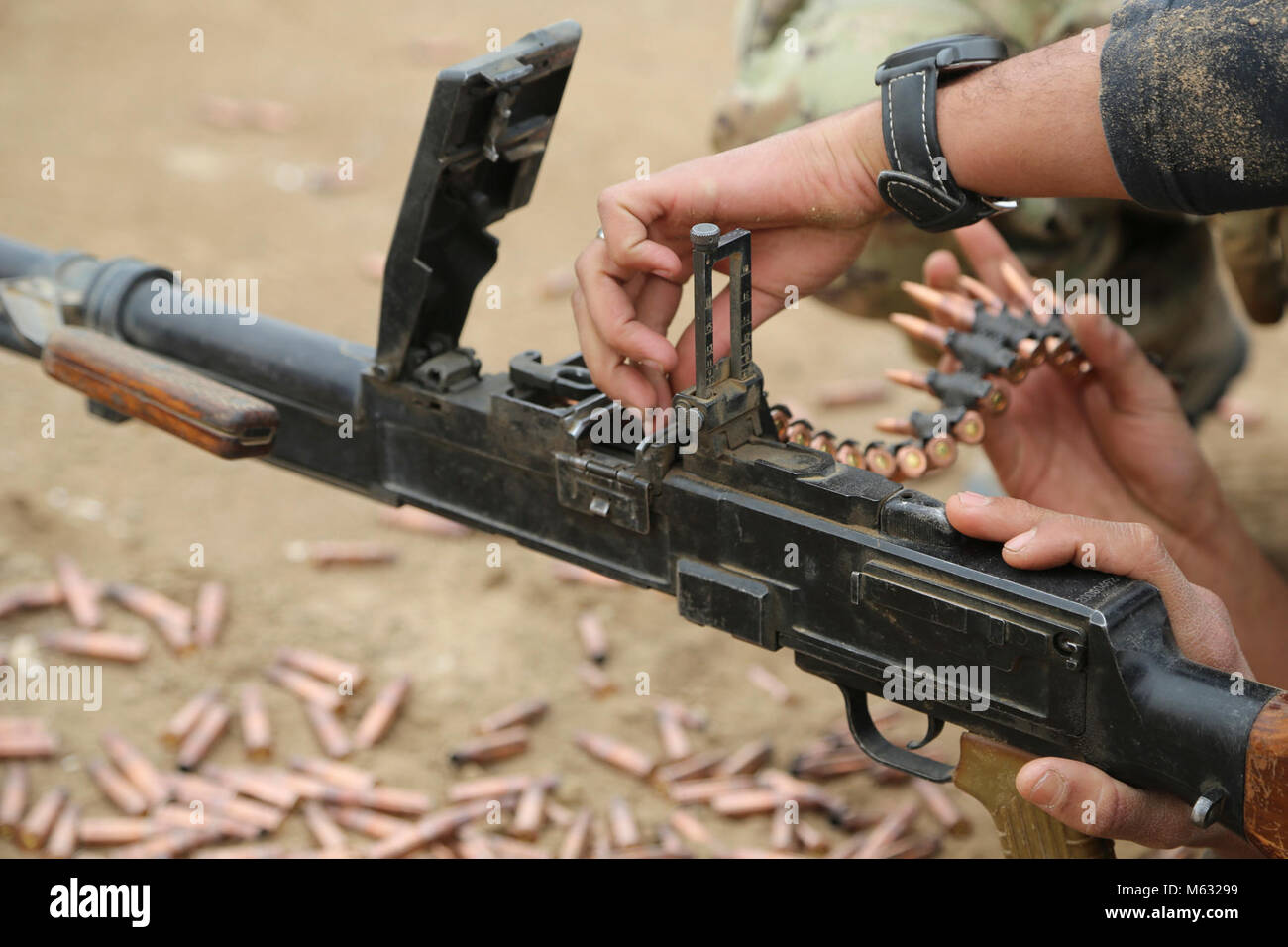 An Iraqi soldier load a belt of ammunition into a PKC machine gun ...