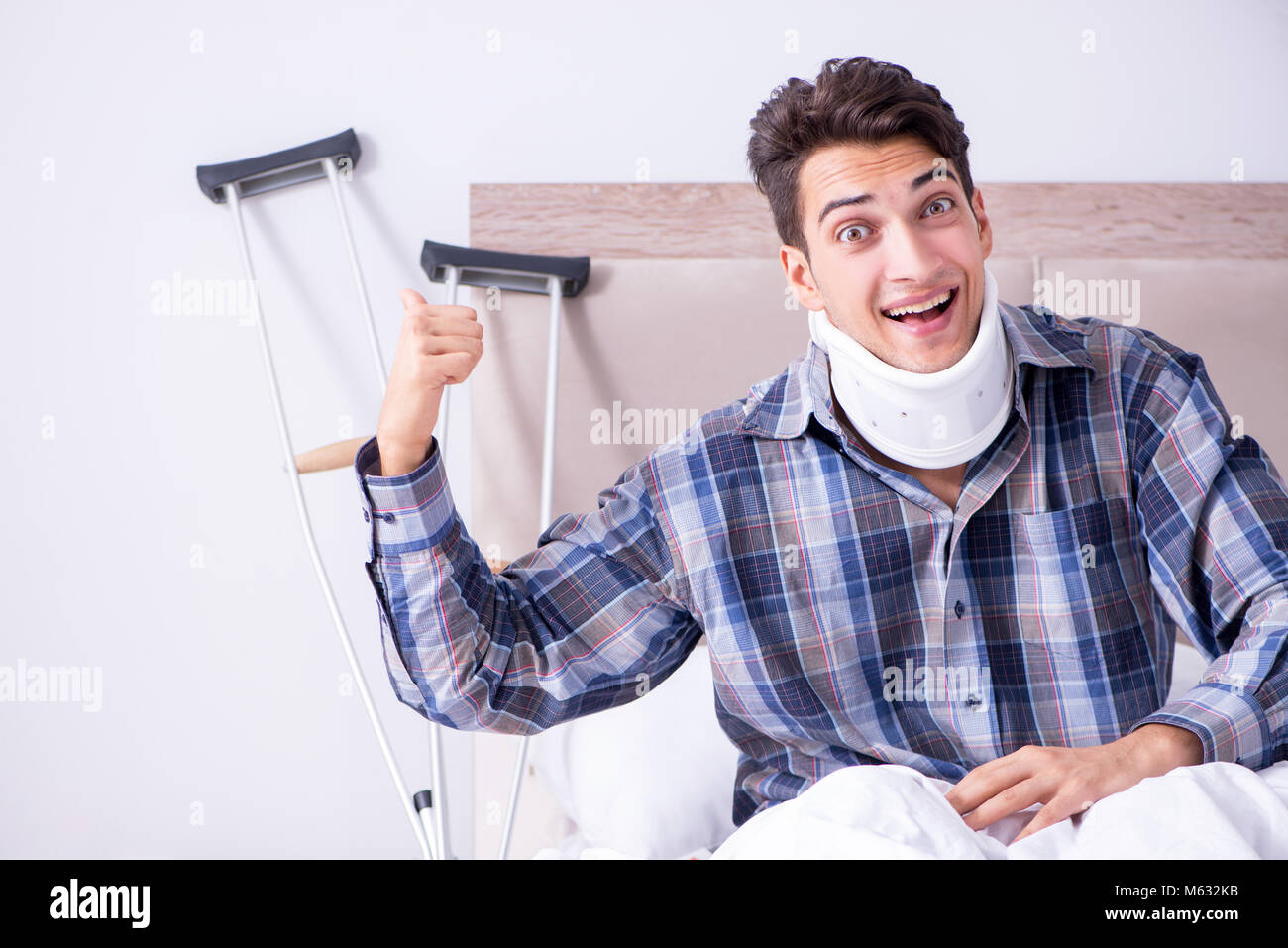 Injured man in bed at home with crutches Stock Photo - Alamy