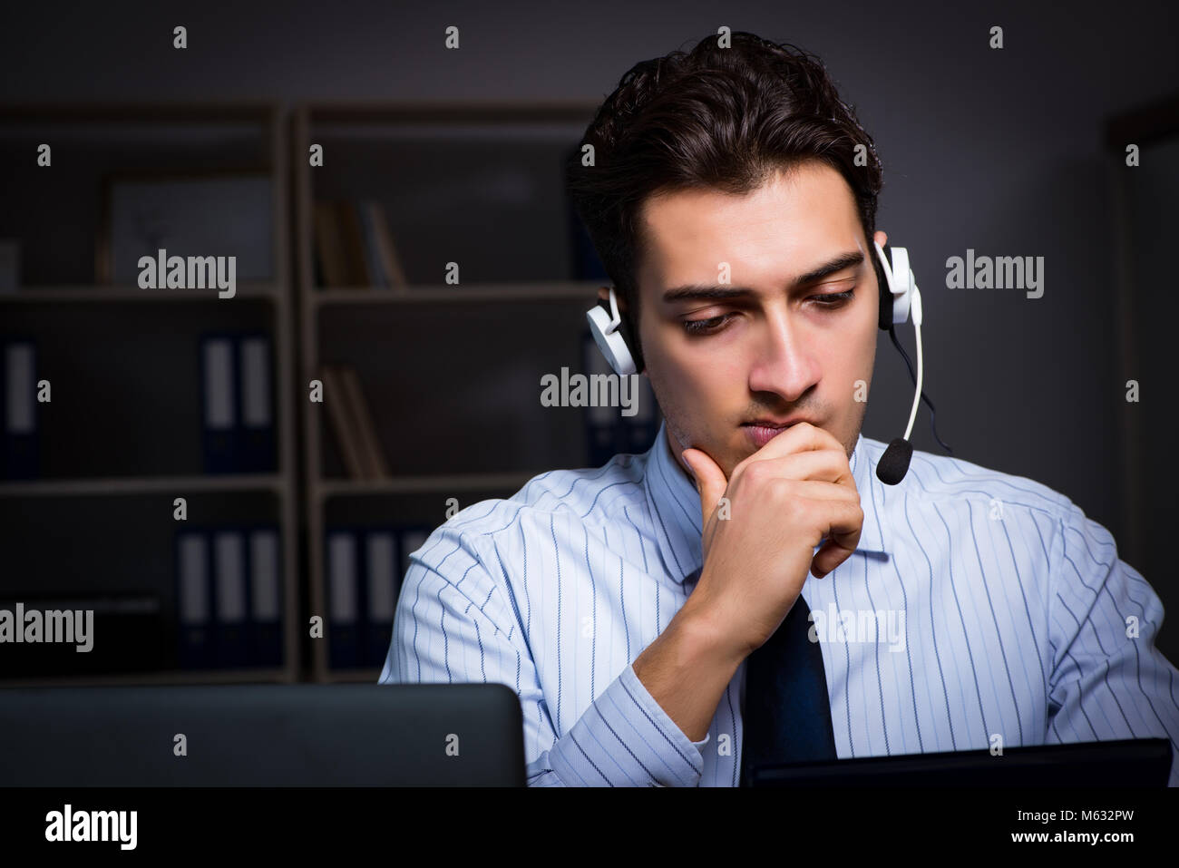 Call center operator talking to customer during night shift Stock Photo ...