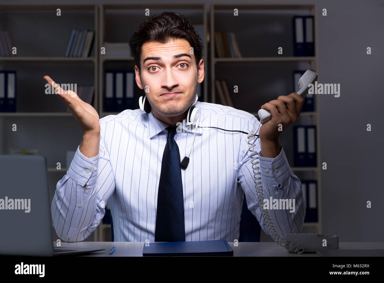 Tired and exhausted helpdesk operator during night shift Stock Photo ...