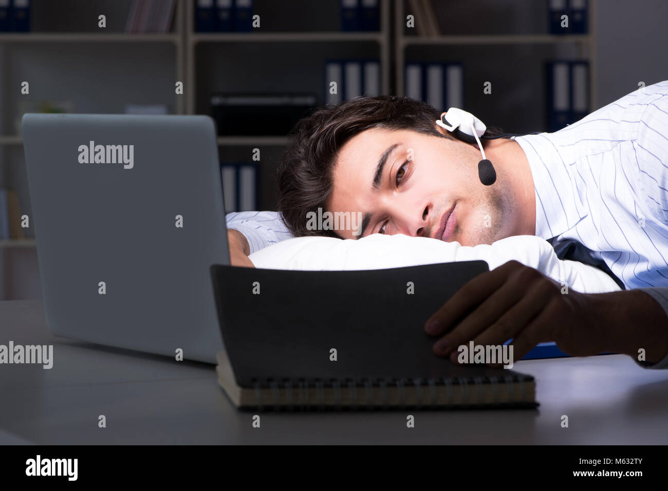 Tired and exhausted helpdesk operator during night shift Stock Photo ...