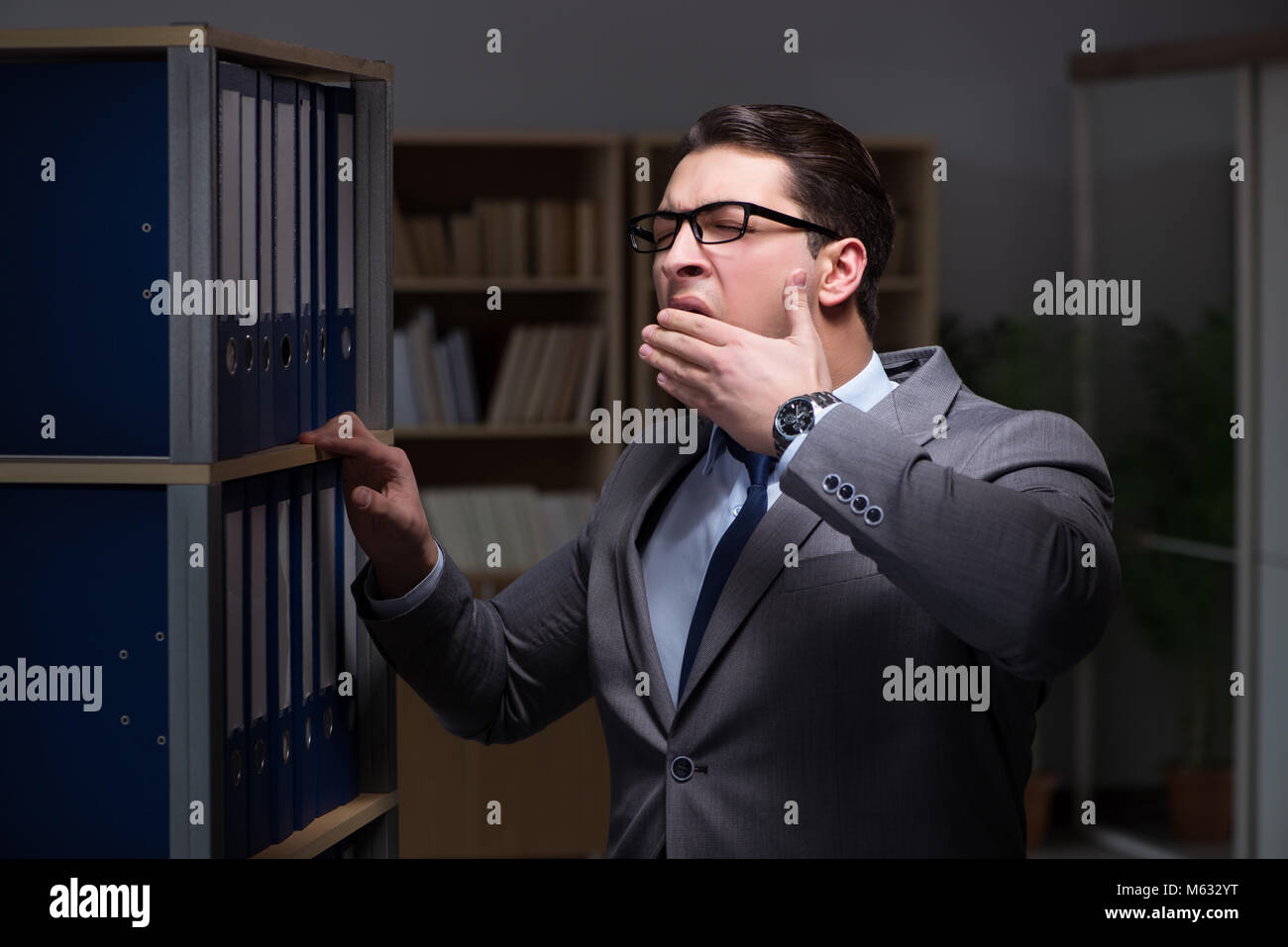 Businessman almost falling asleep working late hours in the office ...
