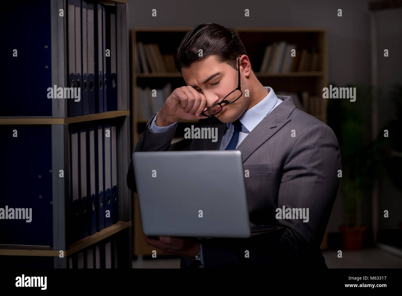 Businessman almost falling asleep working late hours in the office ...
