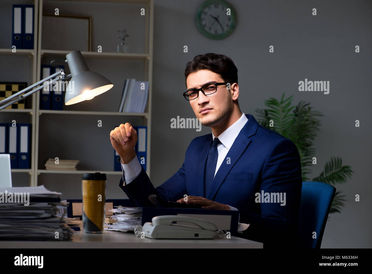 Employee working late to finish important deliverable task Stock Photo ...