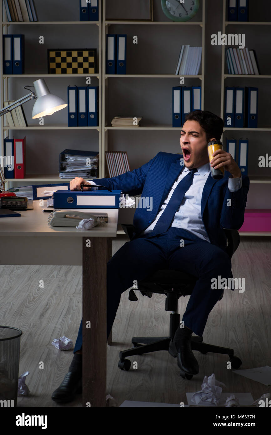 Employee working late and drinking strong coffee to stay awake Stock ...