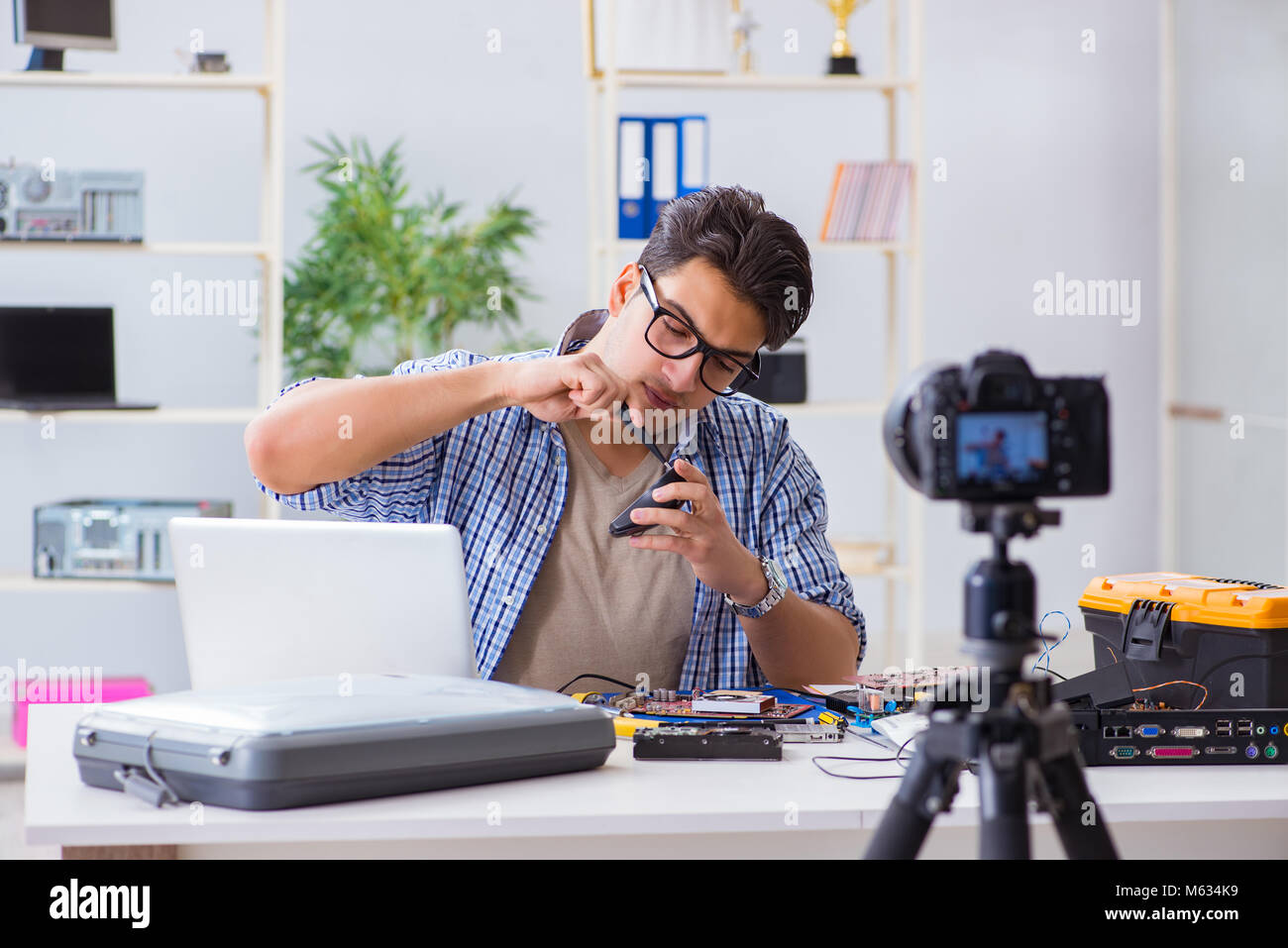Vlogger recording computer repair on camera for vlog blog Stock Photo - Alamy