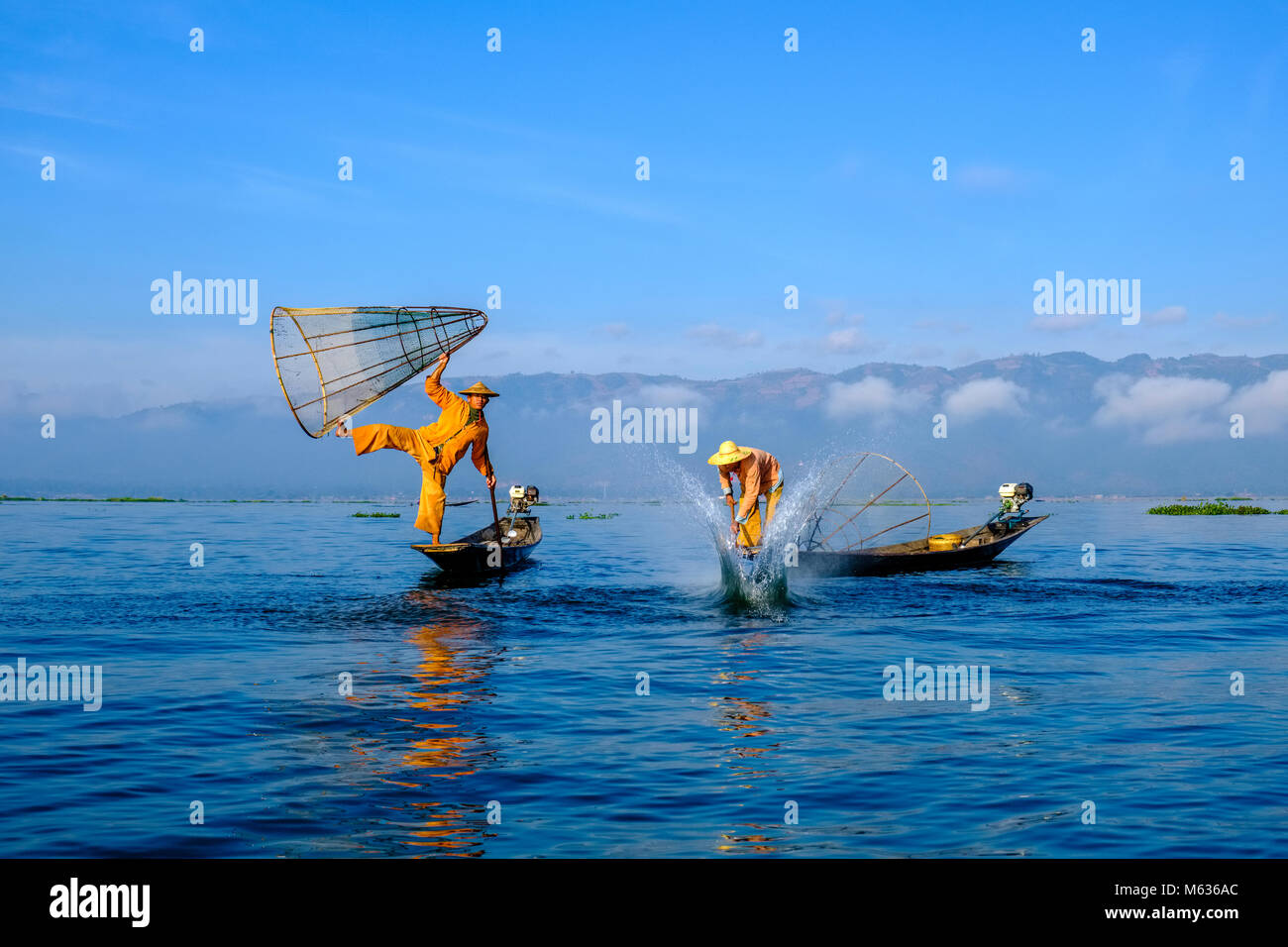 Two fishermen, standing on their boats, are fishing the traditional way ...