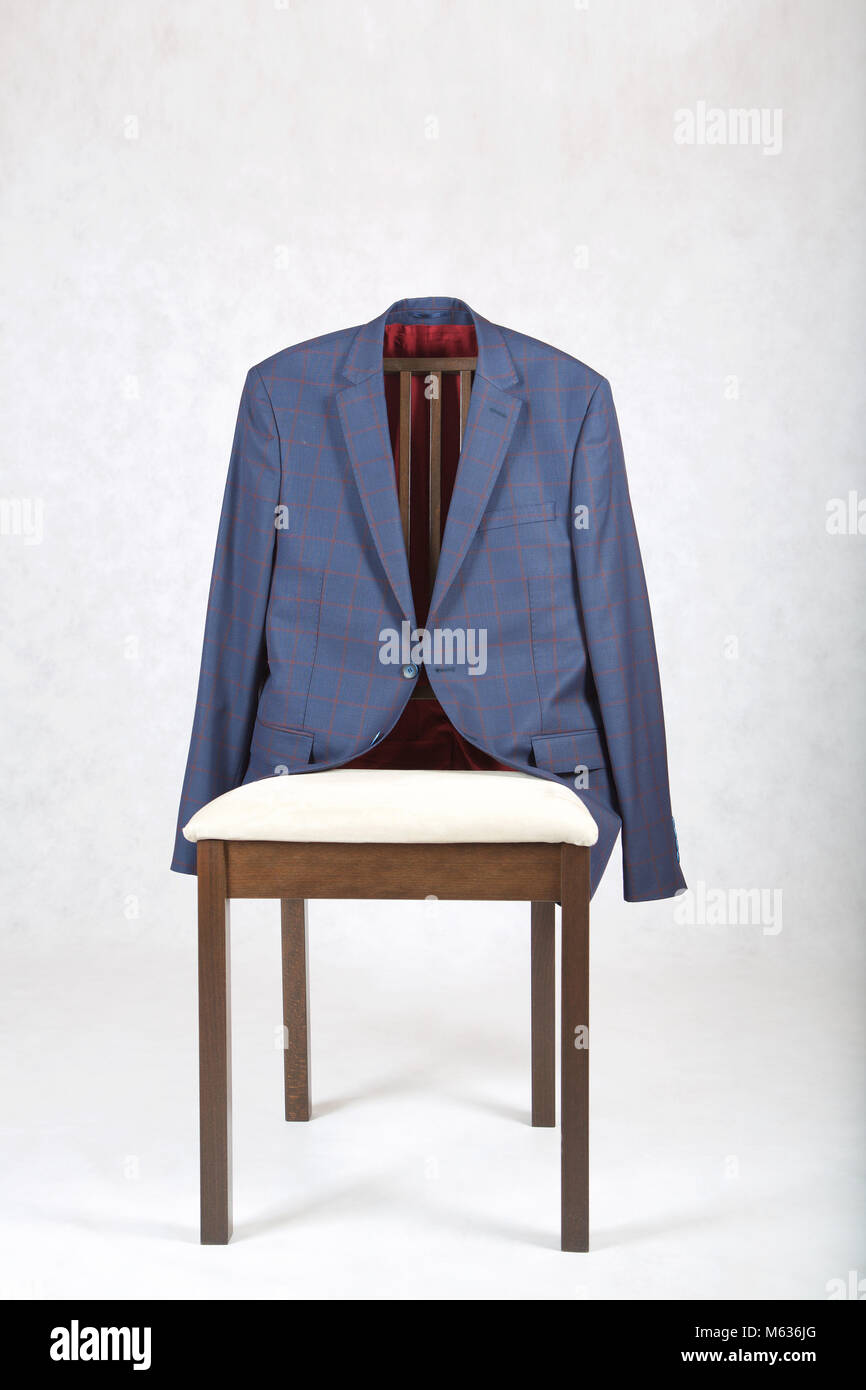 Male classical jacket is hanging on a chair. Gray background Stock ...