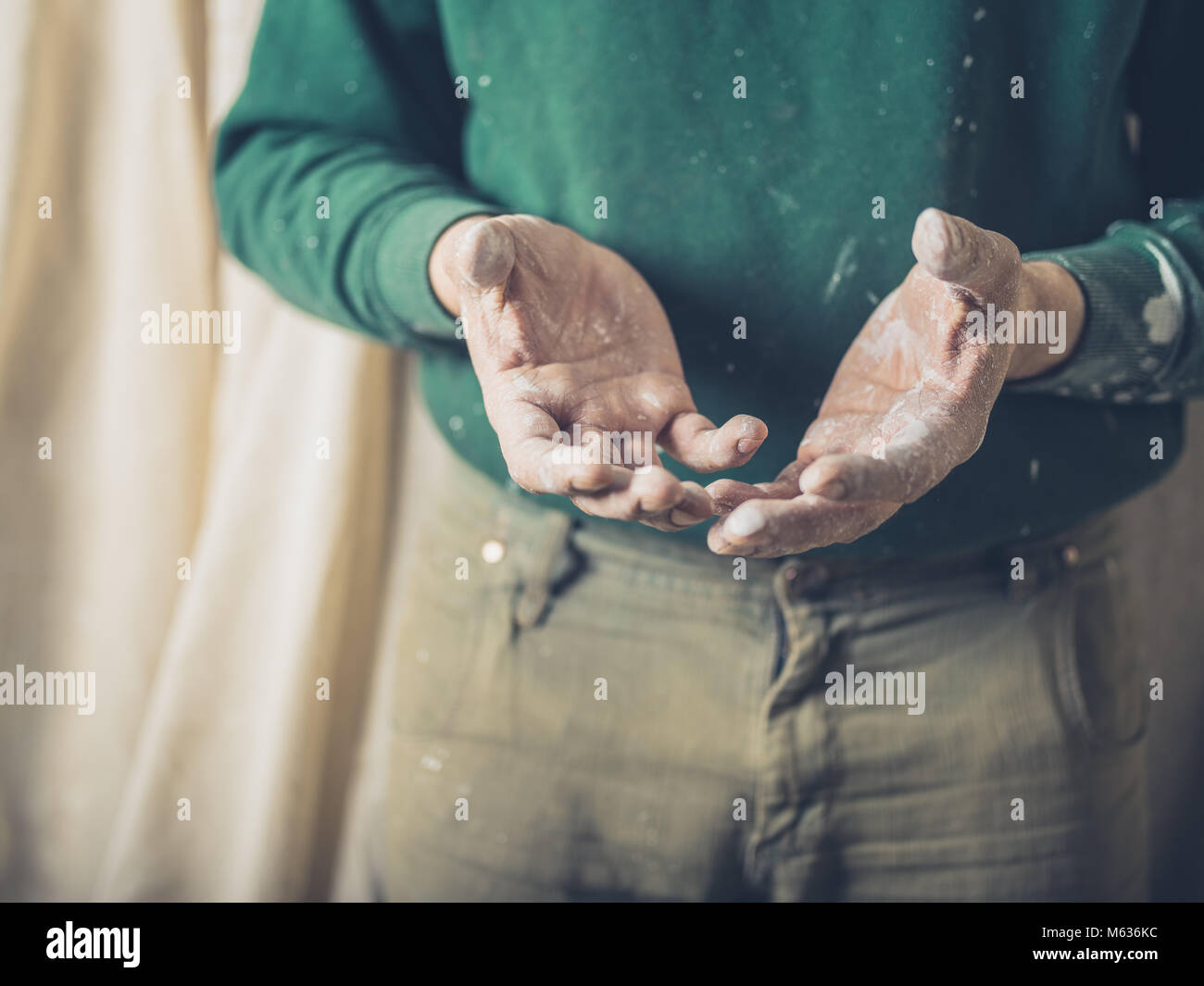 A man is standing by a dust cover with paint on his hands Stock Photo ...