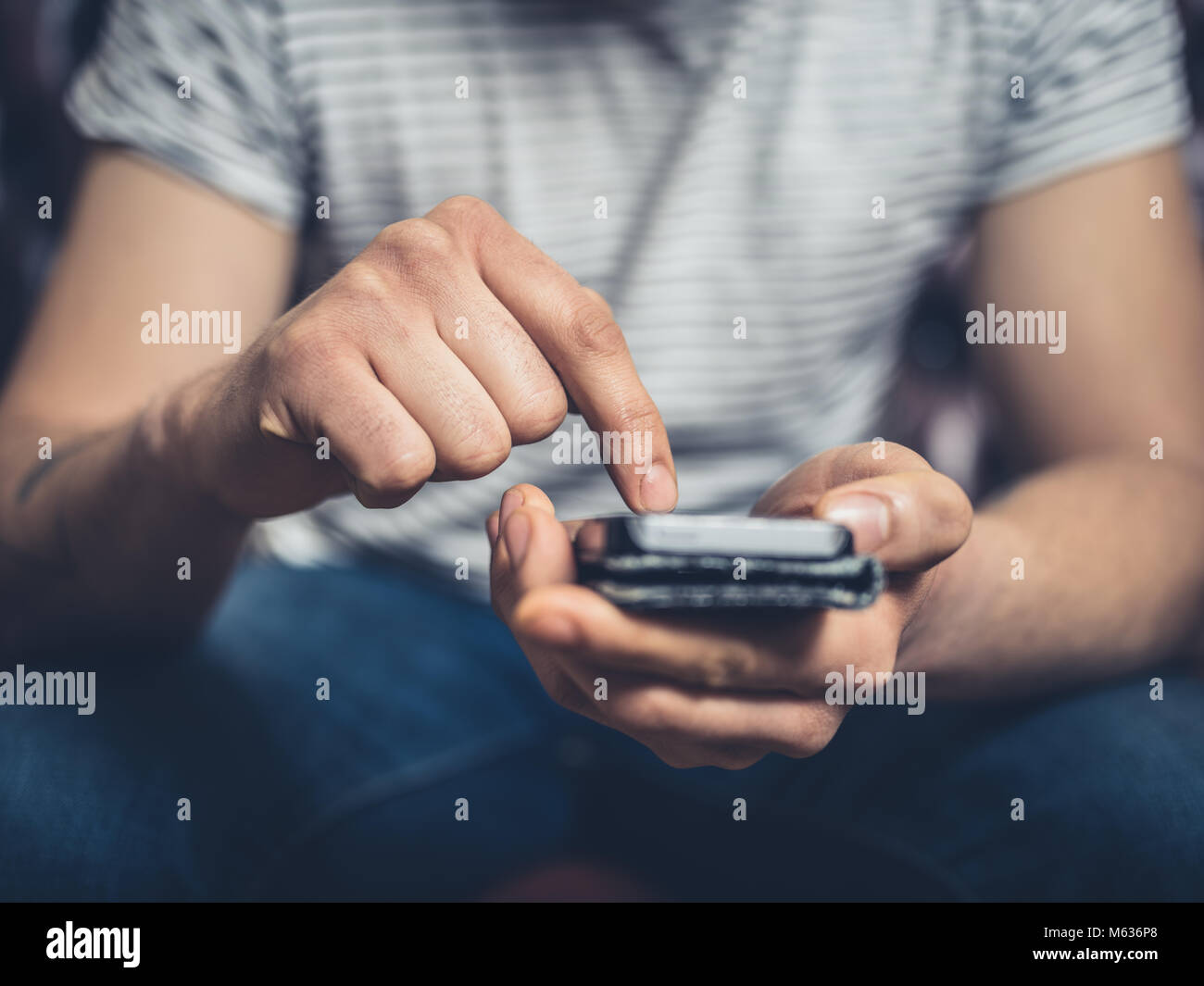 Close up on a man using a smartphone swiping his finger on the screen ...