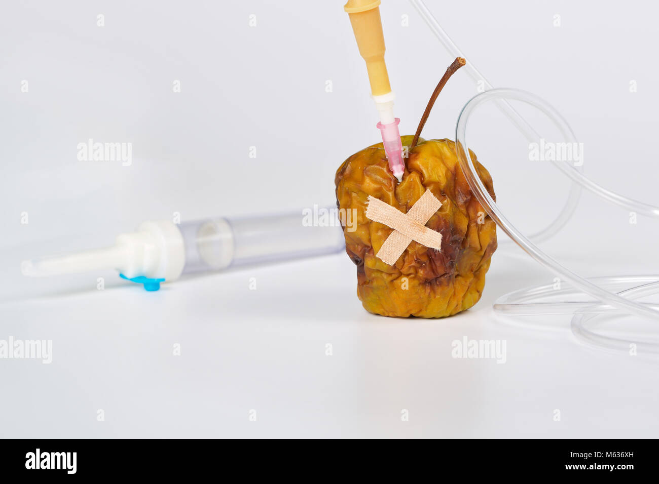 Shrivelled apple with blood transfusion set. Closeup Stock Photo - Alamy