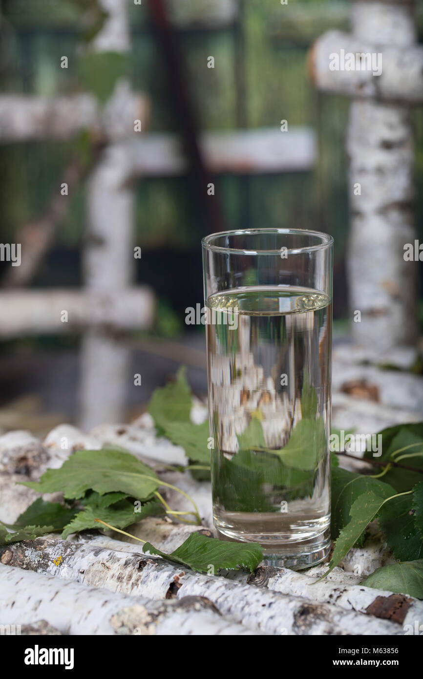 Glass of birch sap water on a birch tree wooden stand. Closeup Stock ...