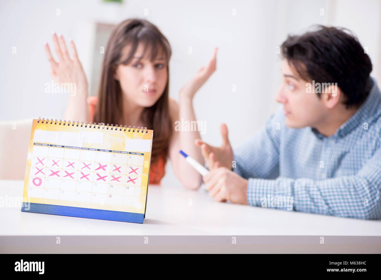 Young family in pregnancy planning concept with ovulation calendar ...