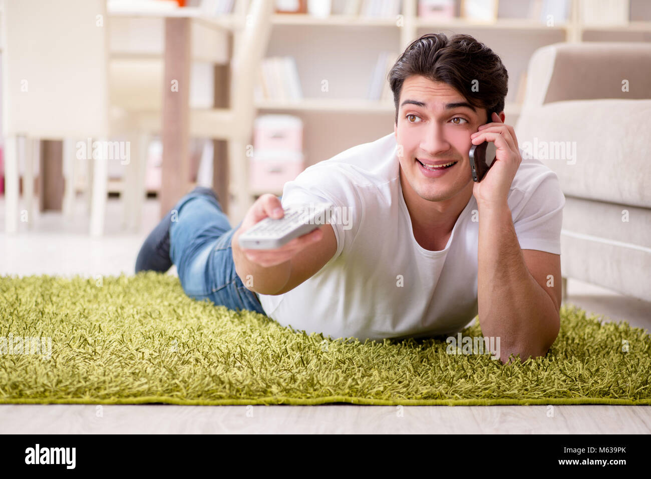 Man watching tv at home on floor Stock Photo - Alamy