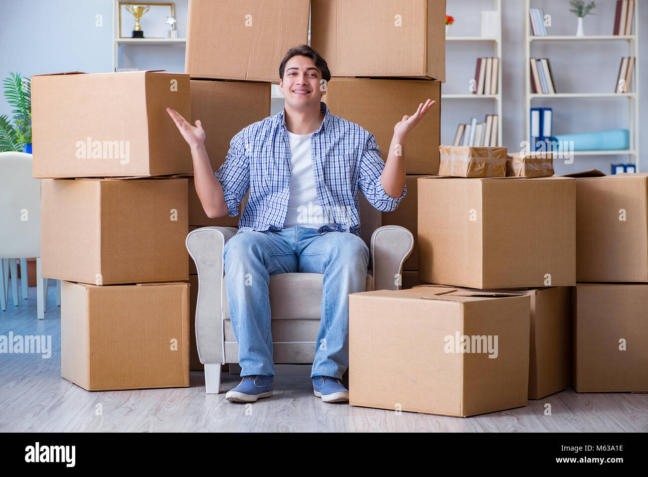 Young man moving in to new house with boxes Stock Photo - Alamy