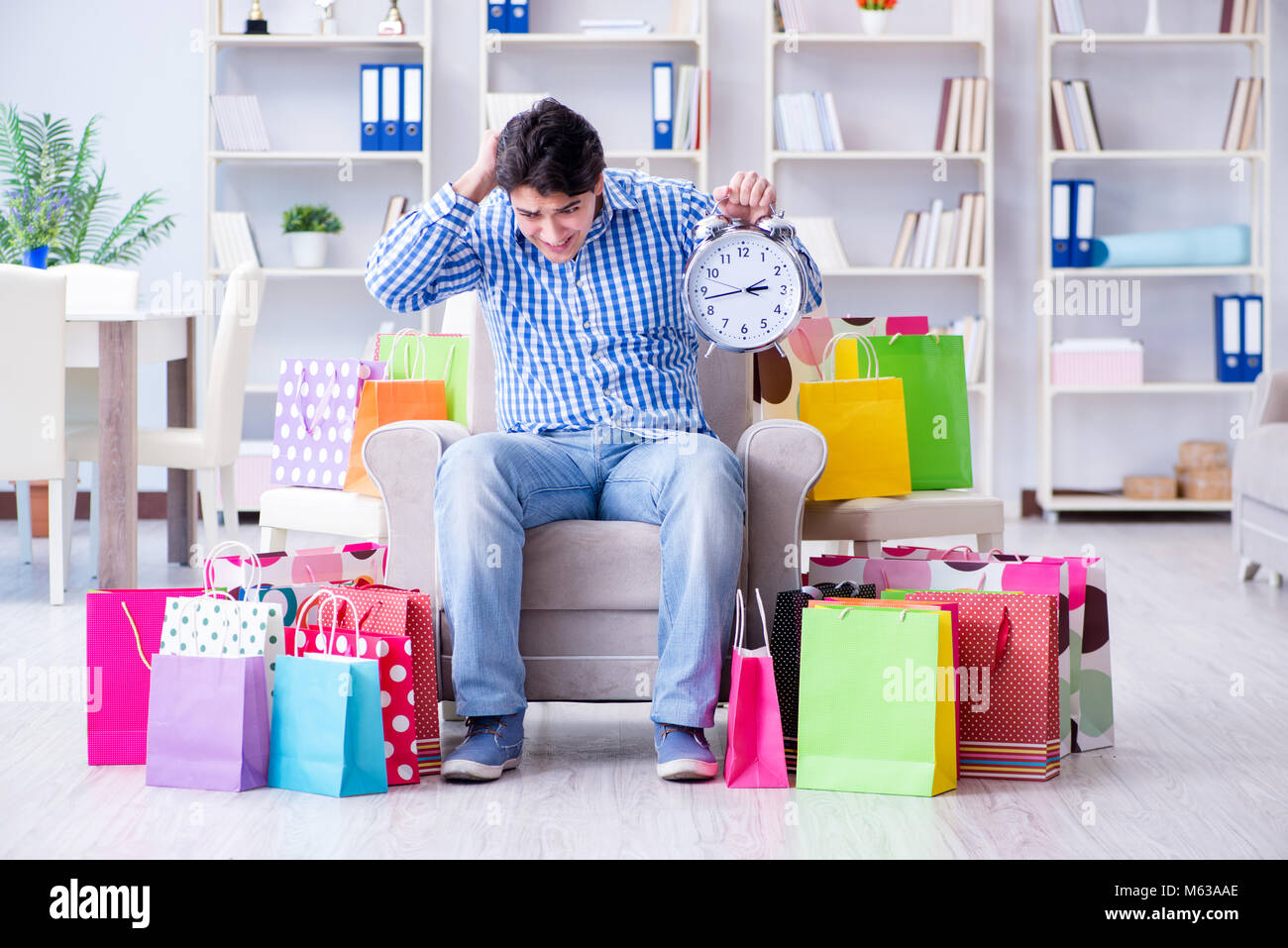 Young man after excessive shopping at home Stock Photo - Alamy