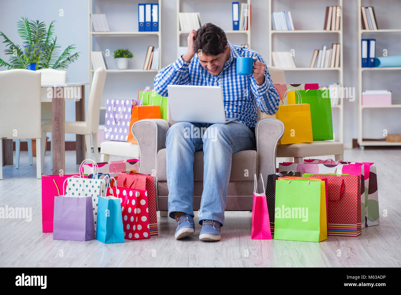 Young man after excessive shopping at home Stock Photo - Alamy