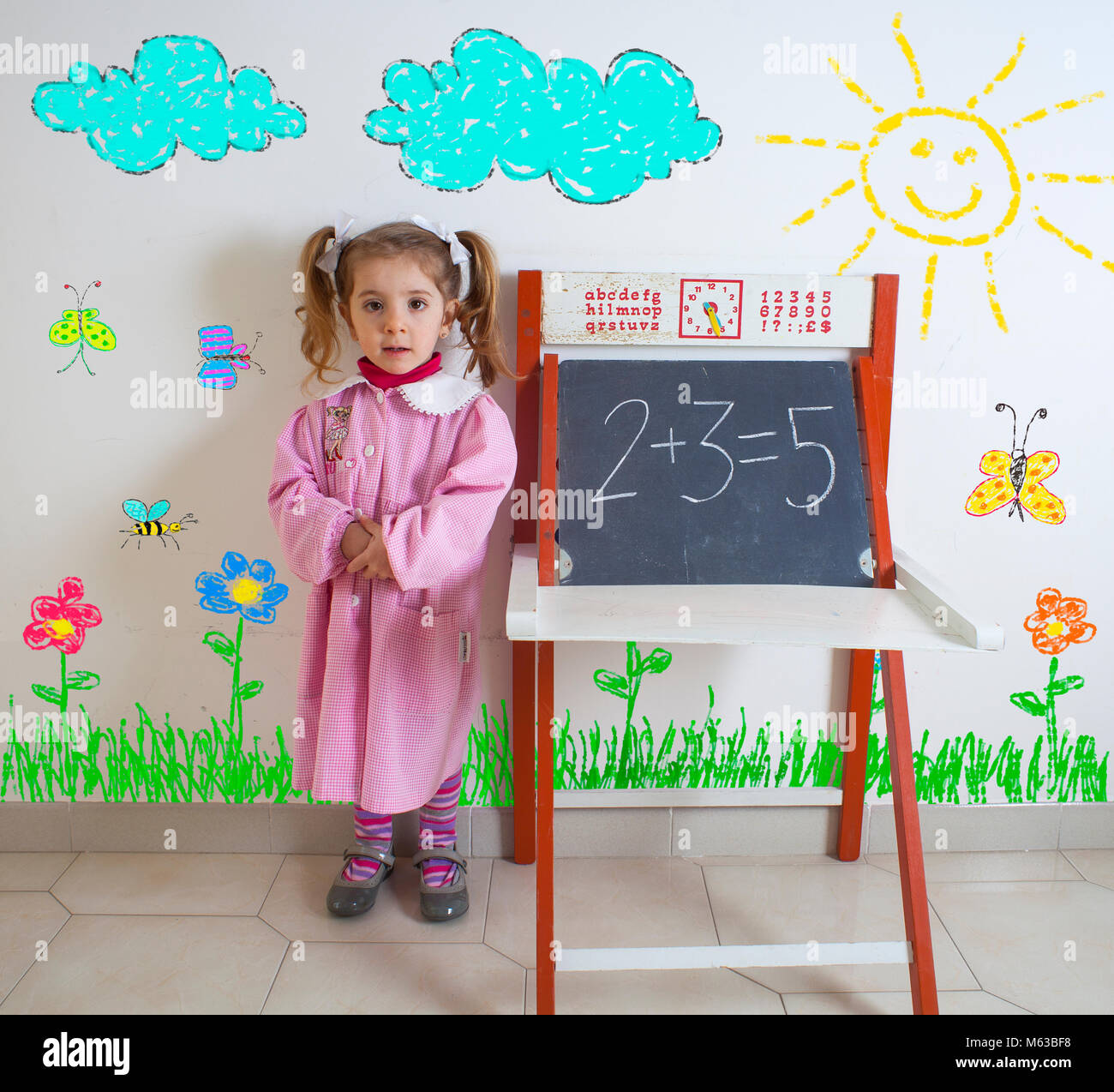 Tender child in smock next to the chalkboard Stock Photo - Alamy