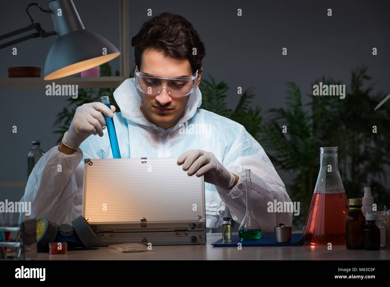 Forensic investigator working in lab looking for evidence Stock Photo ...