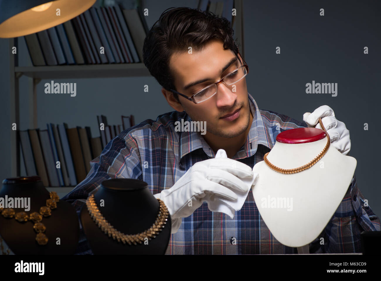 Young male jeweller working at night in his workshop Stock Photo - Alamy