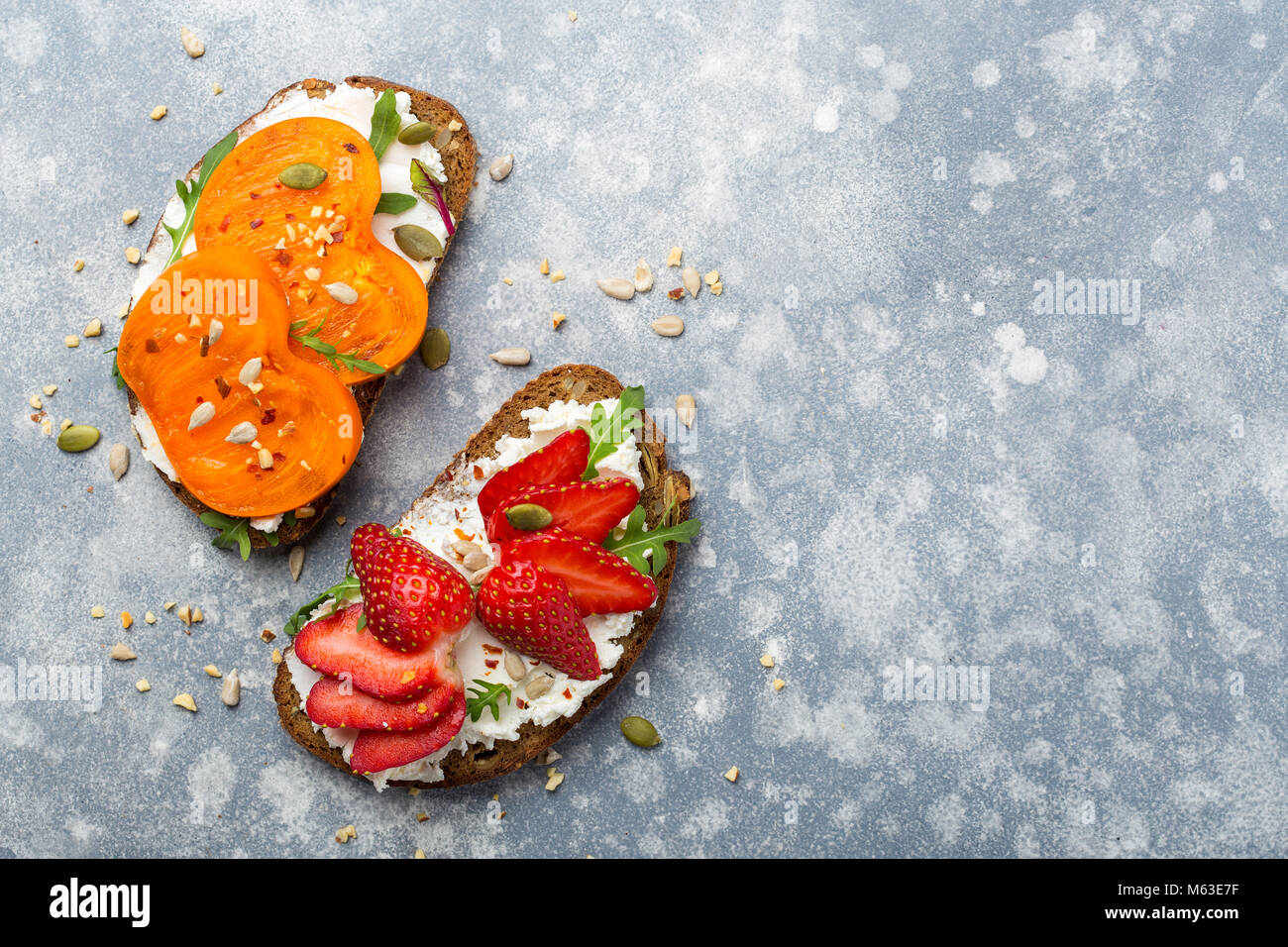 Two rye bread and cream cheese sandwiches over grey background and a ...