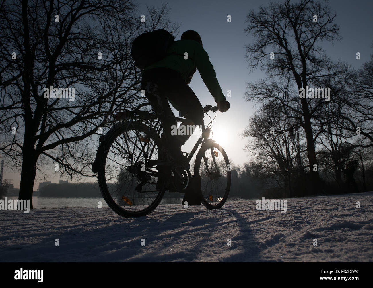 Berlin, Germany. 13th Feb, 2018. A man riding a bike through the snow ...