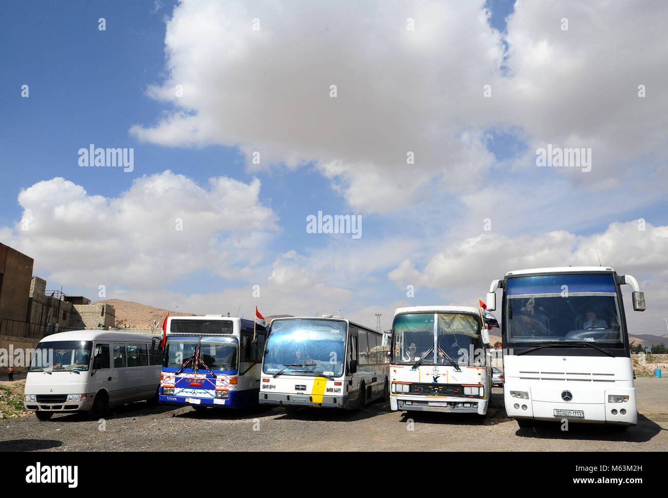 Damascus, Syria. 28th Feb, 2018. Syrian buses wait at a designated ...