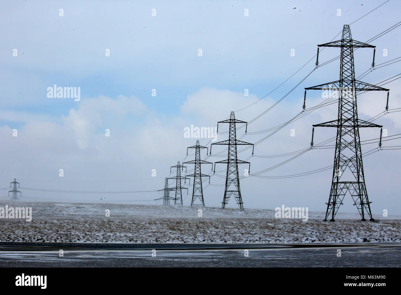 A row of pylons in a snowy landscape on the Rochdale to Halifax Road ...
