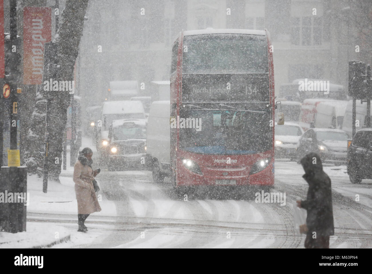 London, UK. 28th February, 2018. Snow sweeps London. A double decker ...
