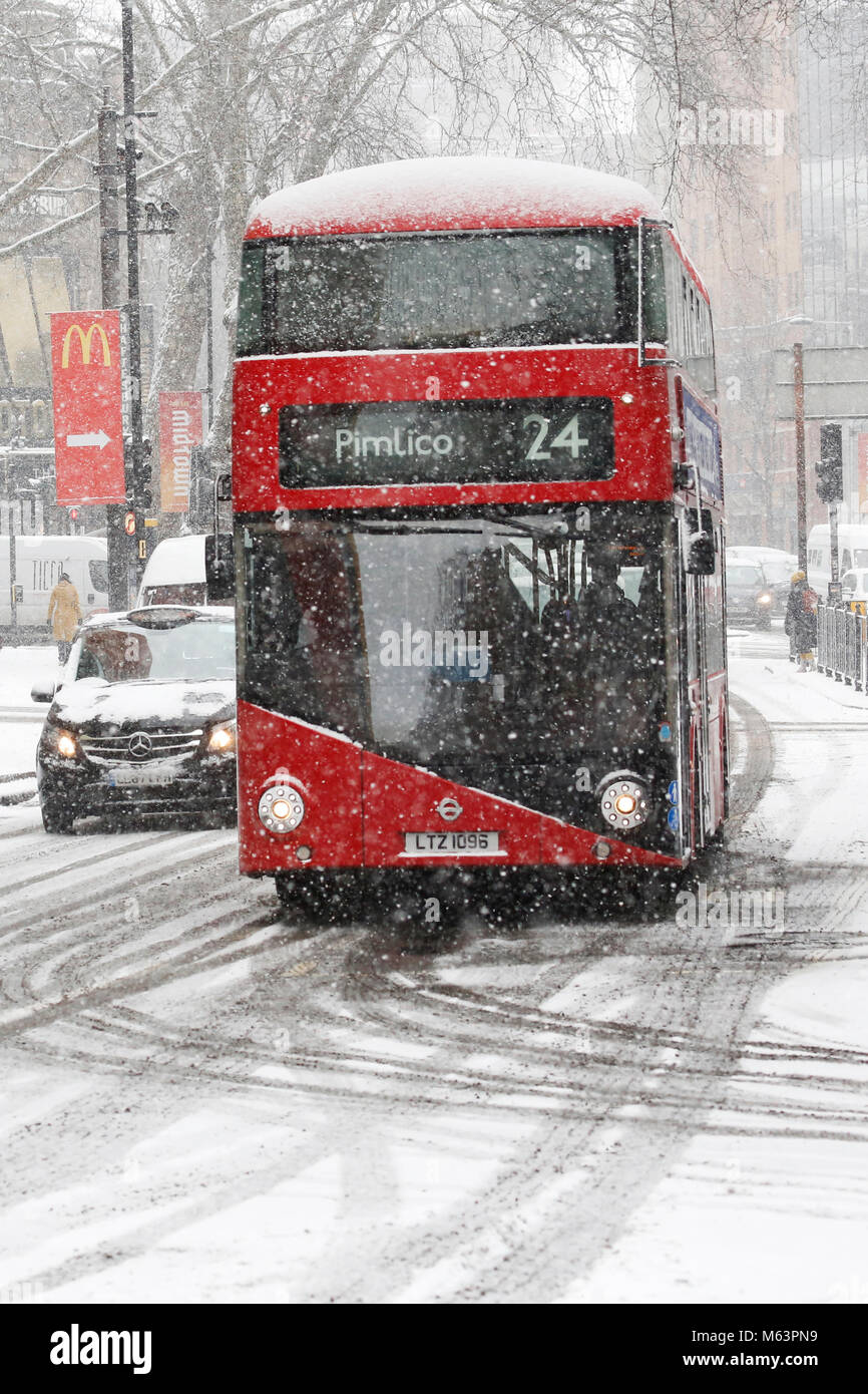 London, UK. 28th February, 2018. Snow sweeps London. A double decker ...