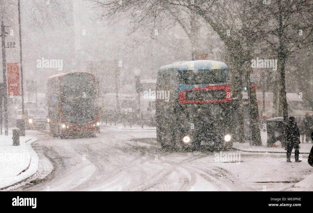 London, UK. 28th February, 2018. Snow sweeps London. A double decker ...