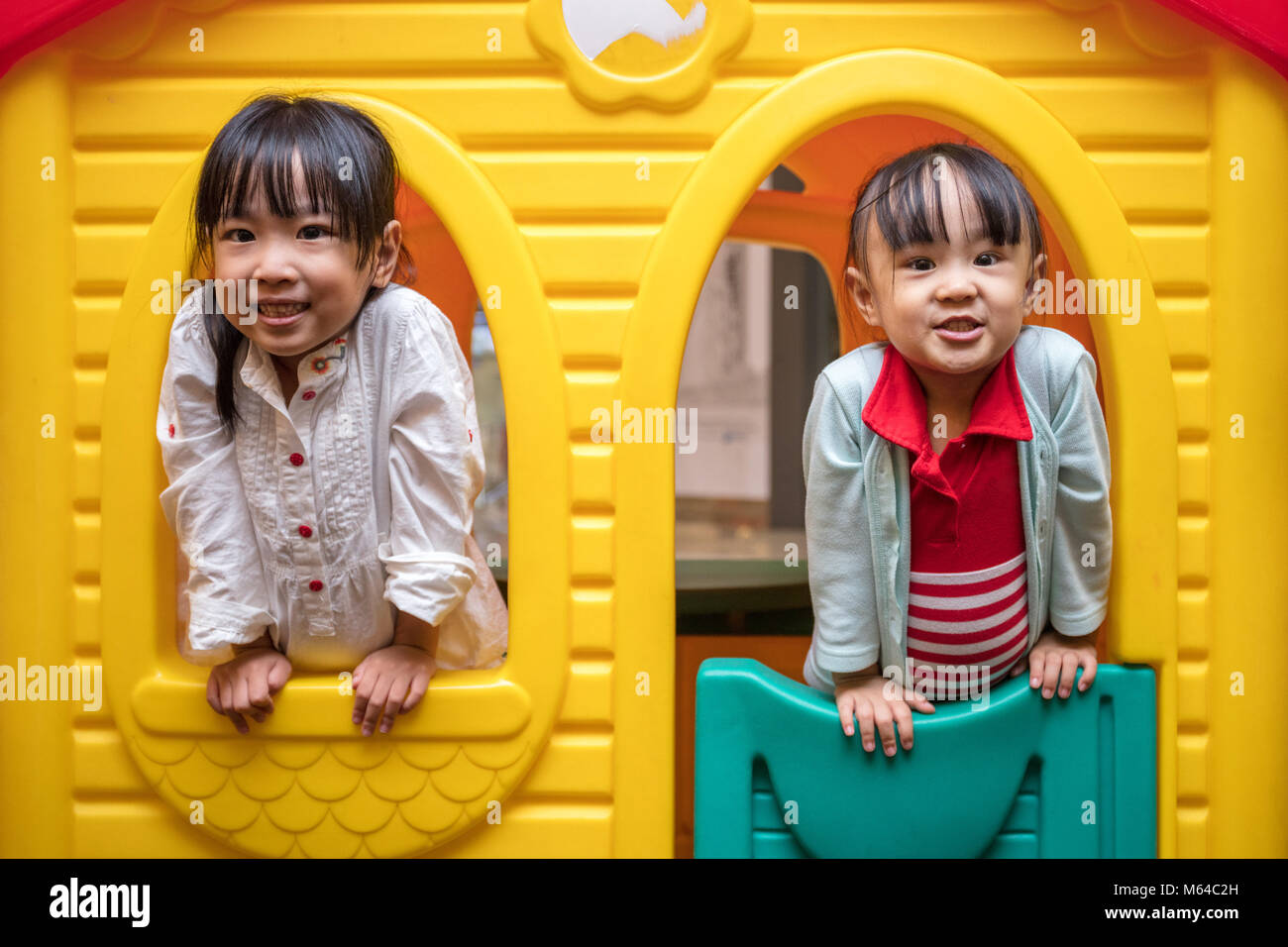 Asian Chinese little girls playing in toy house at indoor playground ...