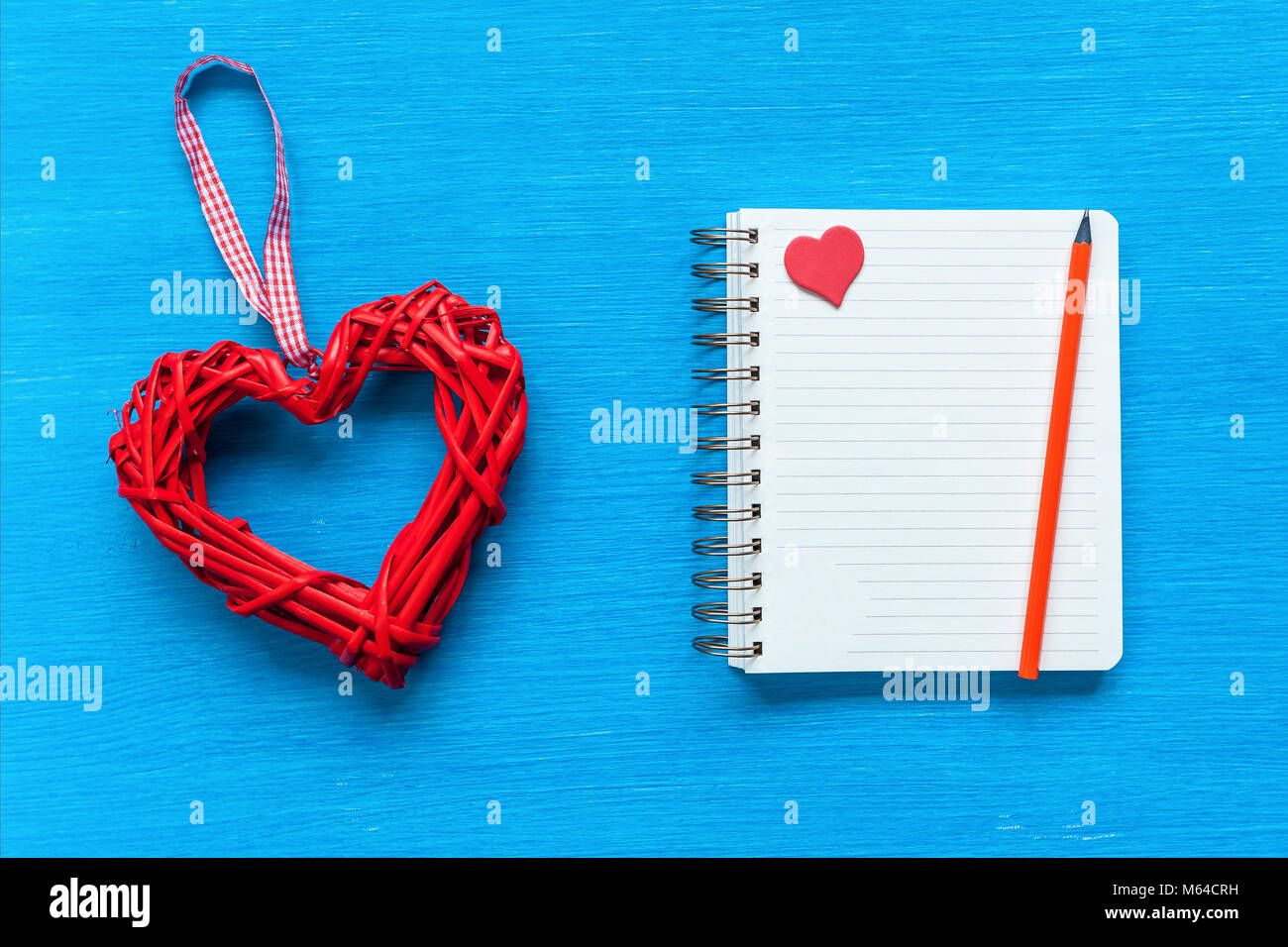 Notepad with multi-colored hearts and a pen lay on a table. Notepad ...