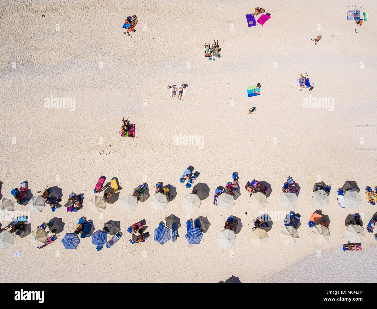People bathing in the sun on the beach. Tourists on a sand beach in ...