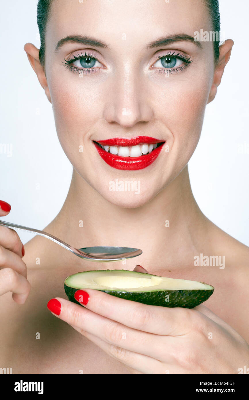 Woman eating avocado Stock Photo - Alamy