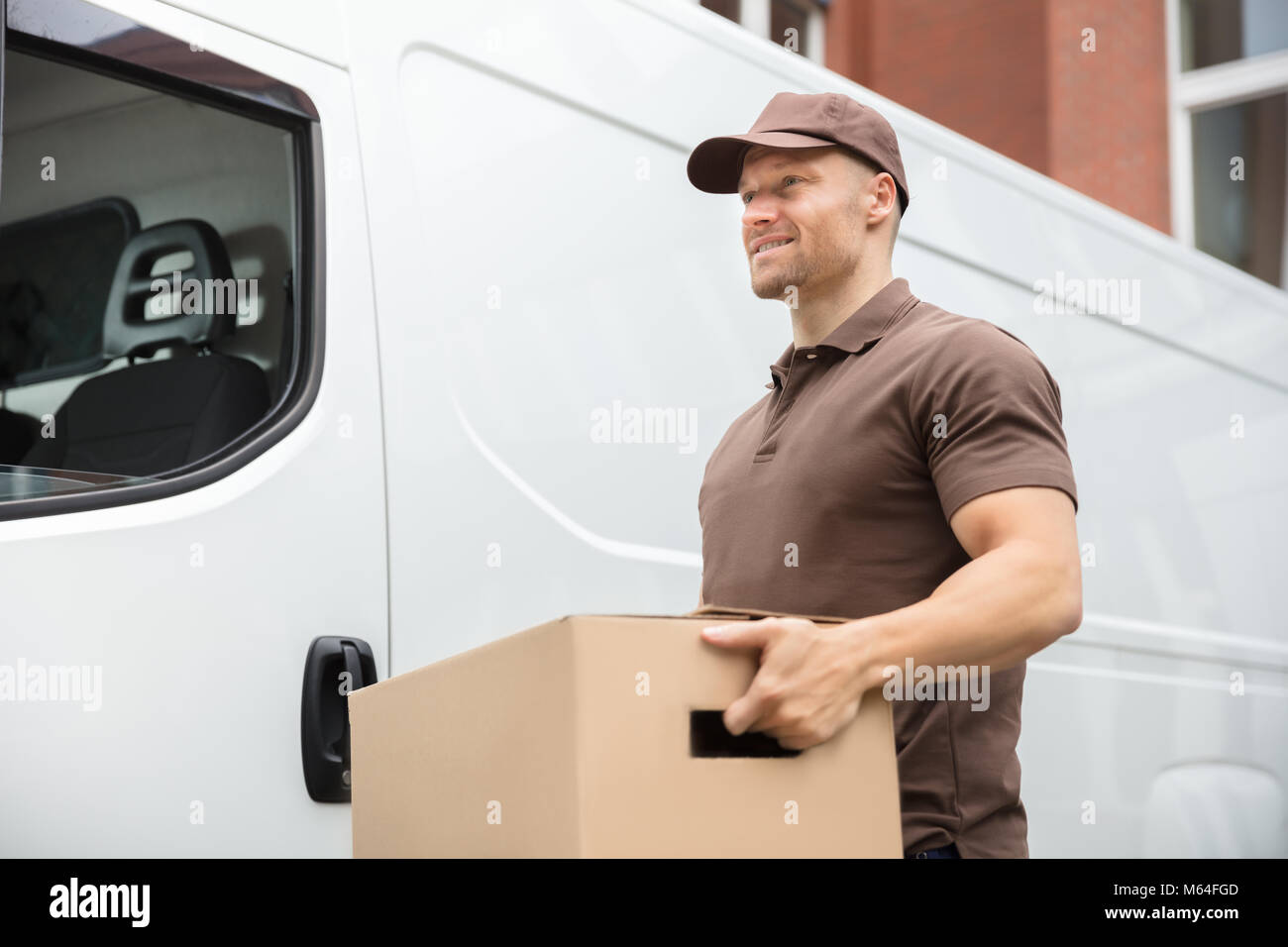 Portrait Of A Happy Young Delivery Man Carrying Cardboard Box Near Van ...