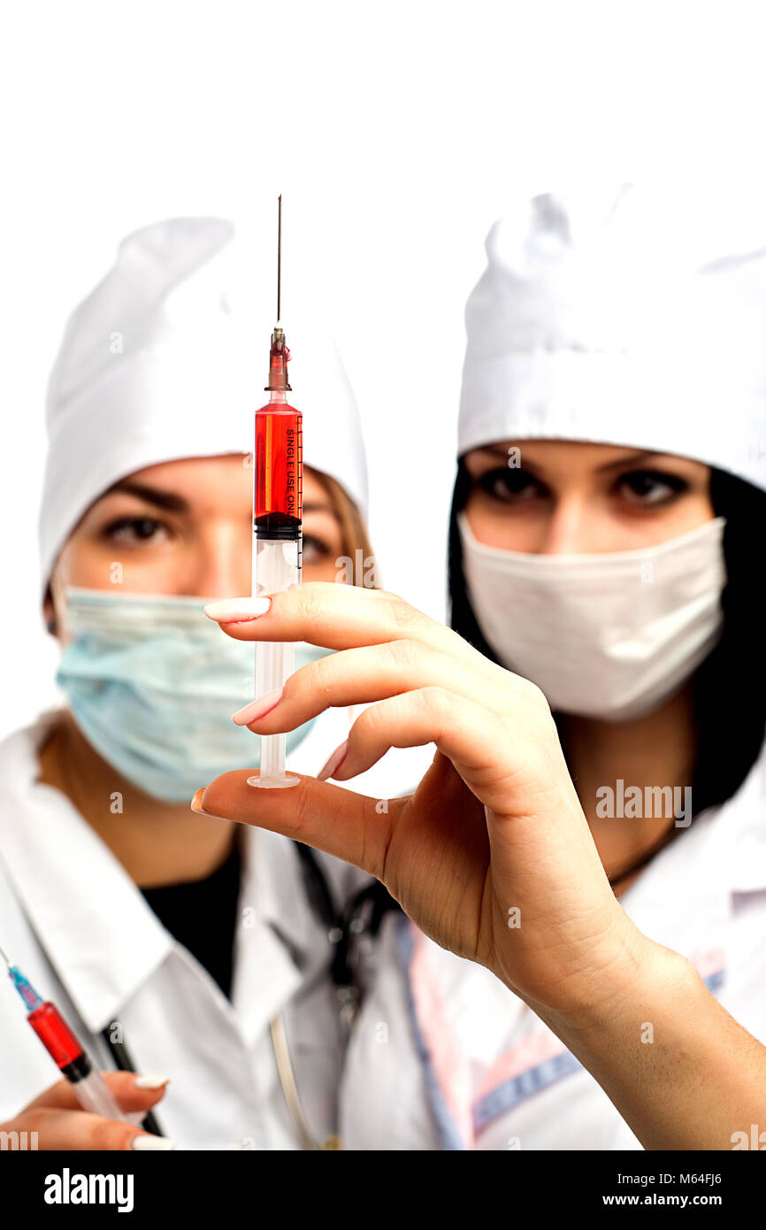 Two female doctors prepare an injection or blood sampling for the ...