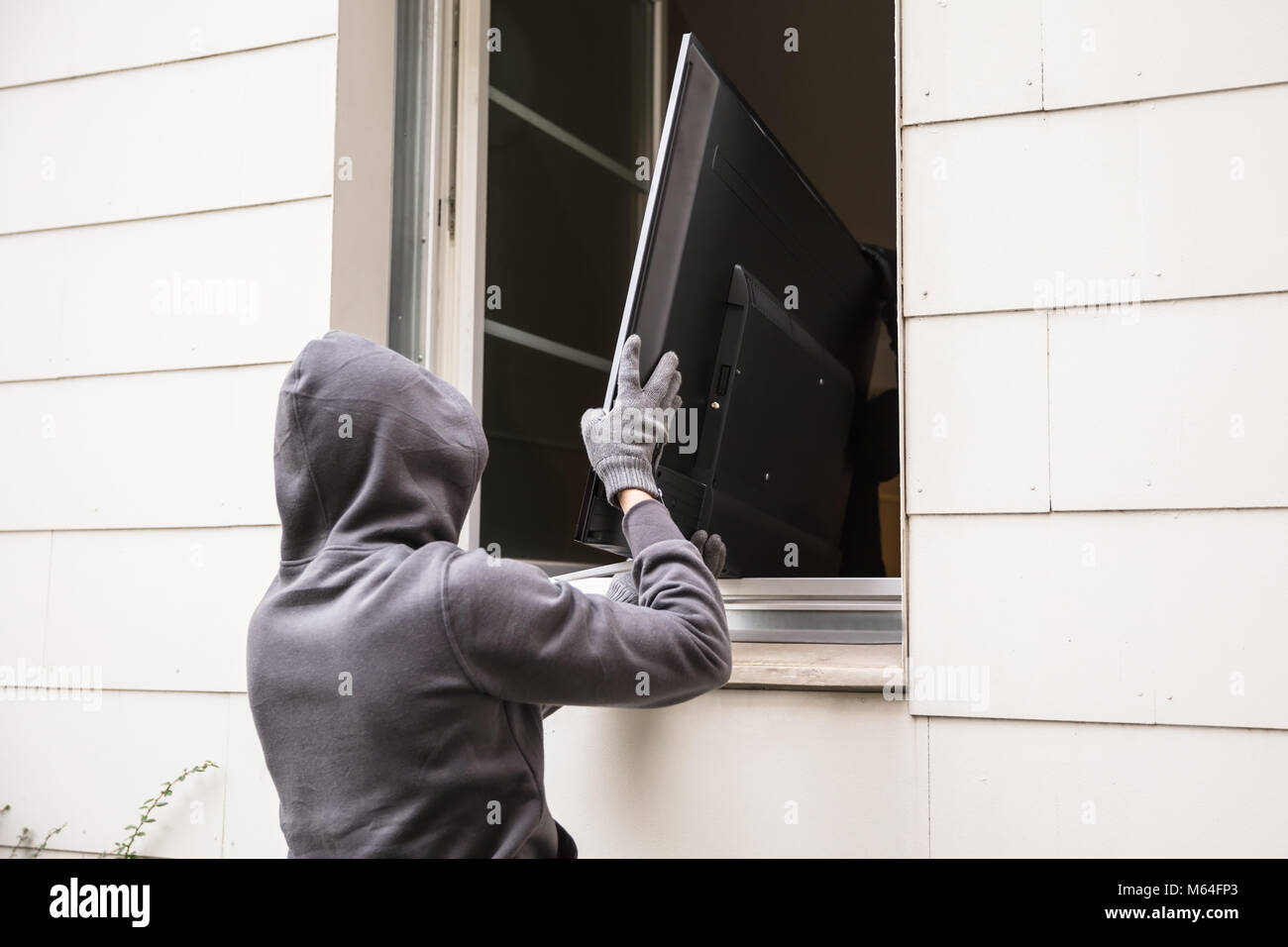 Male Robbers In Hoods Stealing Television Through House Window Stock ...