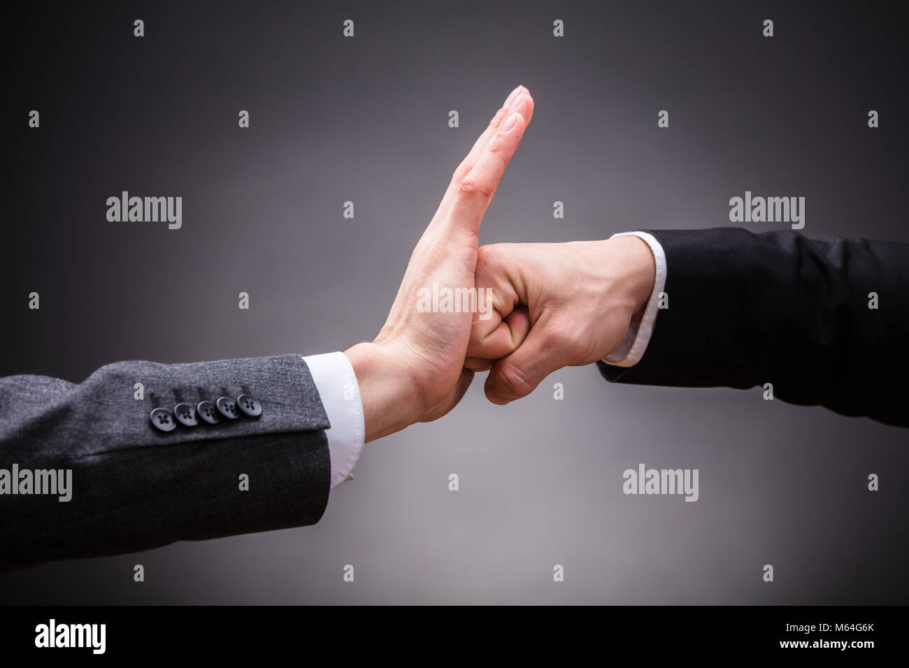 Human Hand Stopping Fist Of Angry Person On Grey Background Stock Photo ...