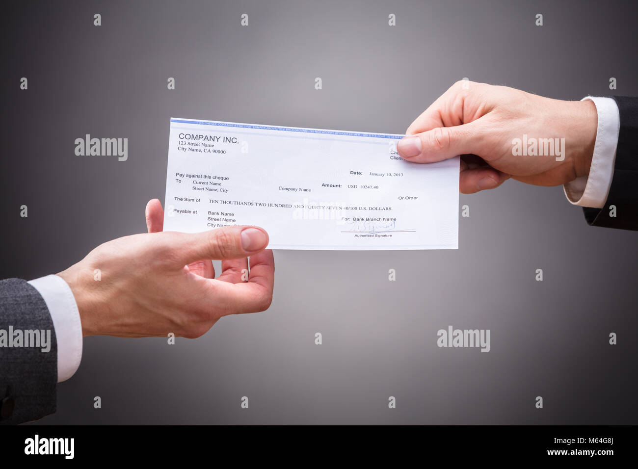 Businessperson Giving Cheque To Colleague On Grey Background Stock ...