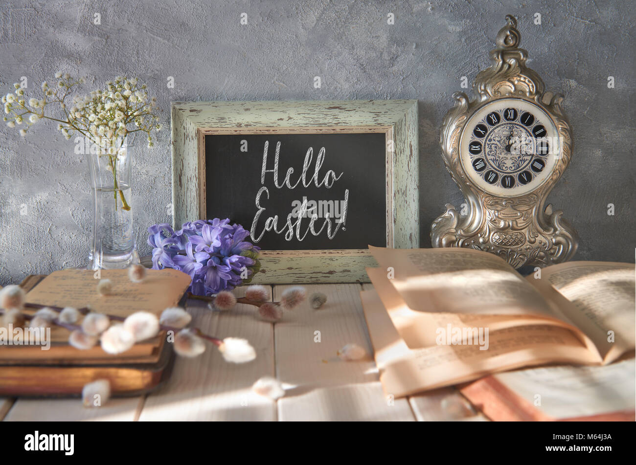 Springtime background with an open book, blackboard with text "Hello ...