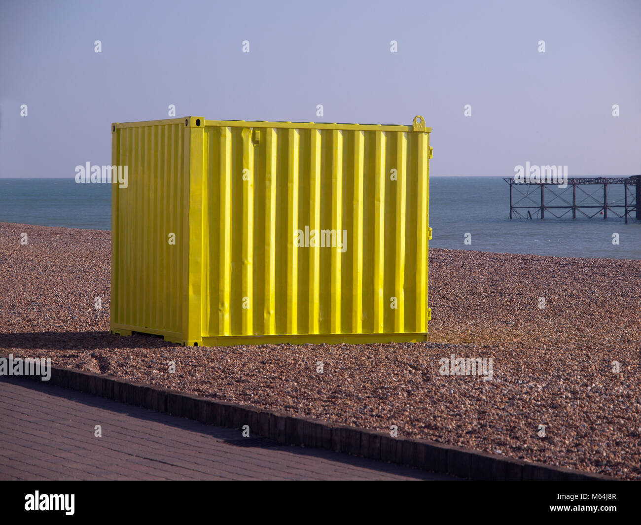 A freshly painted yellow container on the beach at Brighton Stock Photo ...