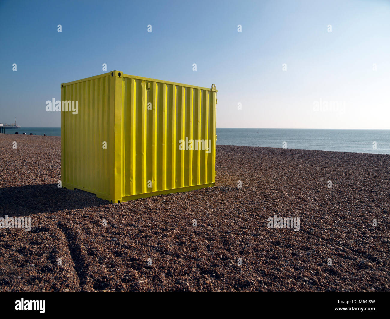 A freshly painted yellow container on the beach at Brighton Stock Photo ...