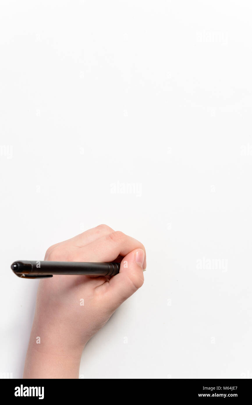 A photo of the hands of a young boy holding pencils and pens on colored ...