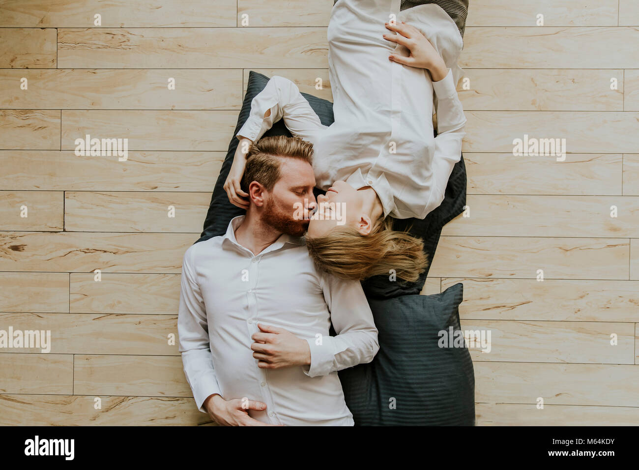 Loving couple lying and kissing on the floor at home Stock Photo - Alamy