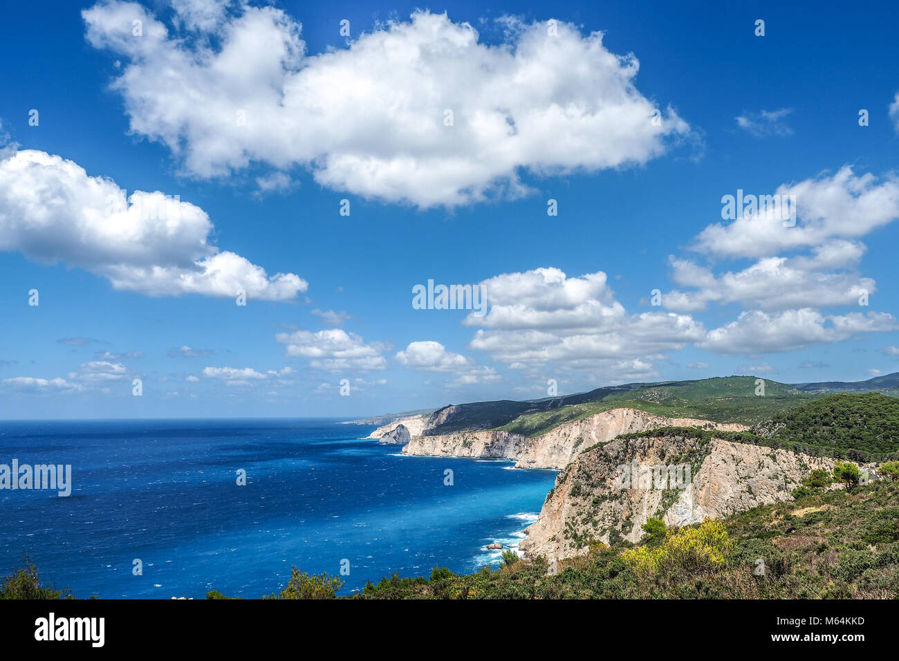 Zakynthos cliff panorama with clear water, blue sky and white clouds ...