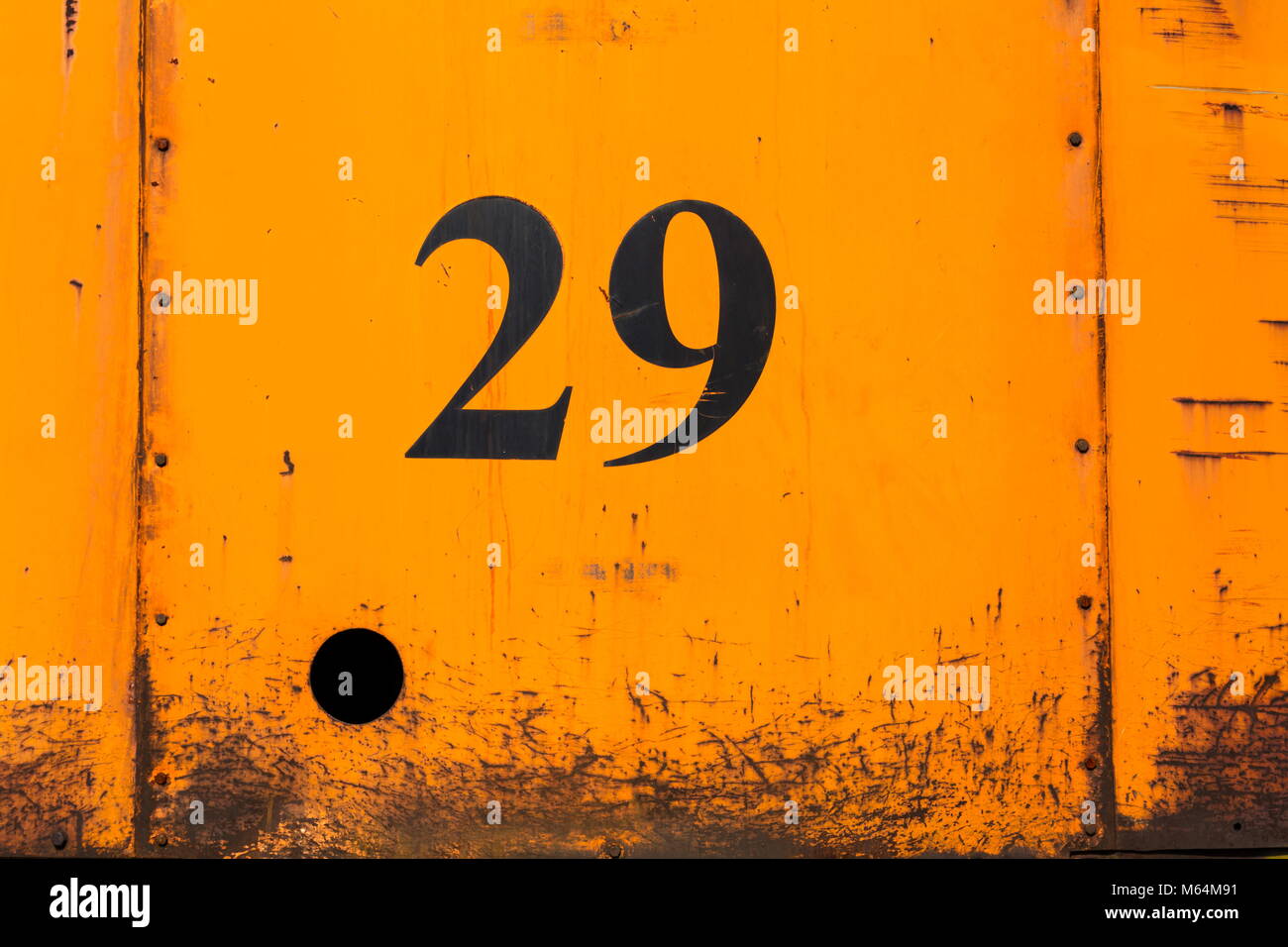 Number 29 on rusty orange metal sheet plate with hole Stock Photo - Alamy