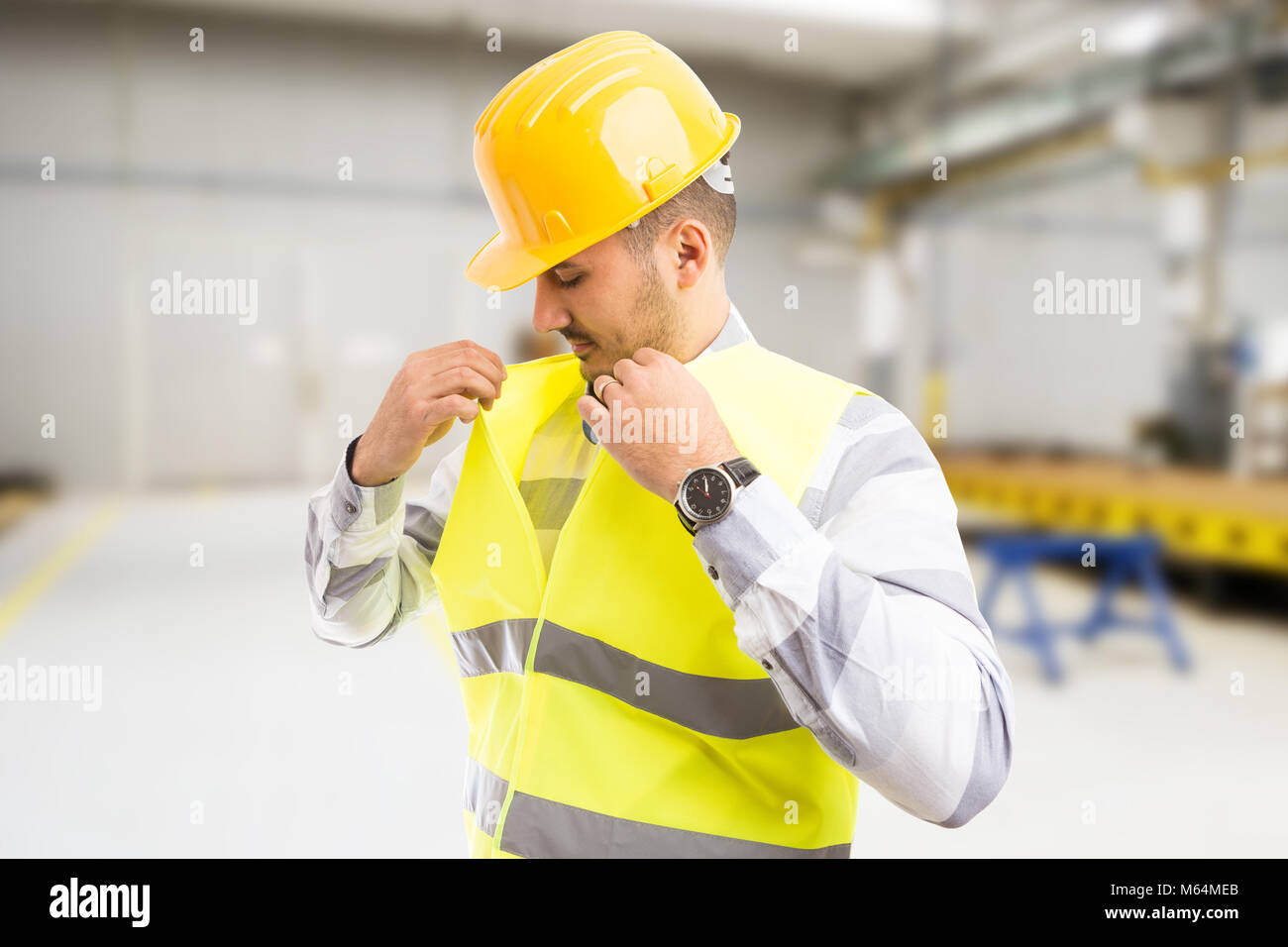 Factory worker or engineer dressing for work inside production hall ...