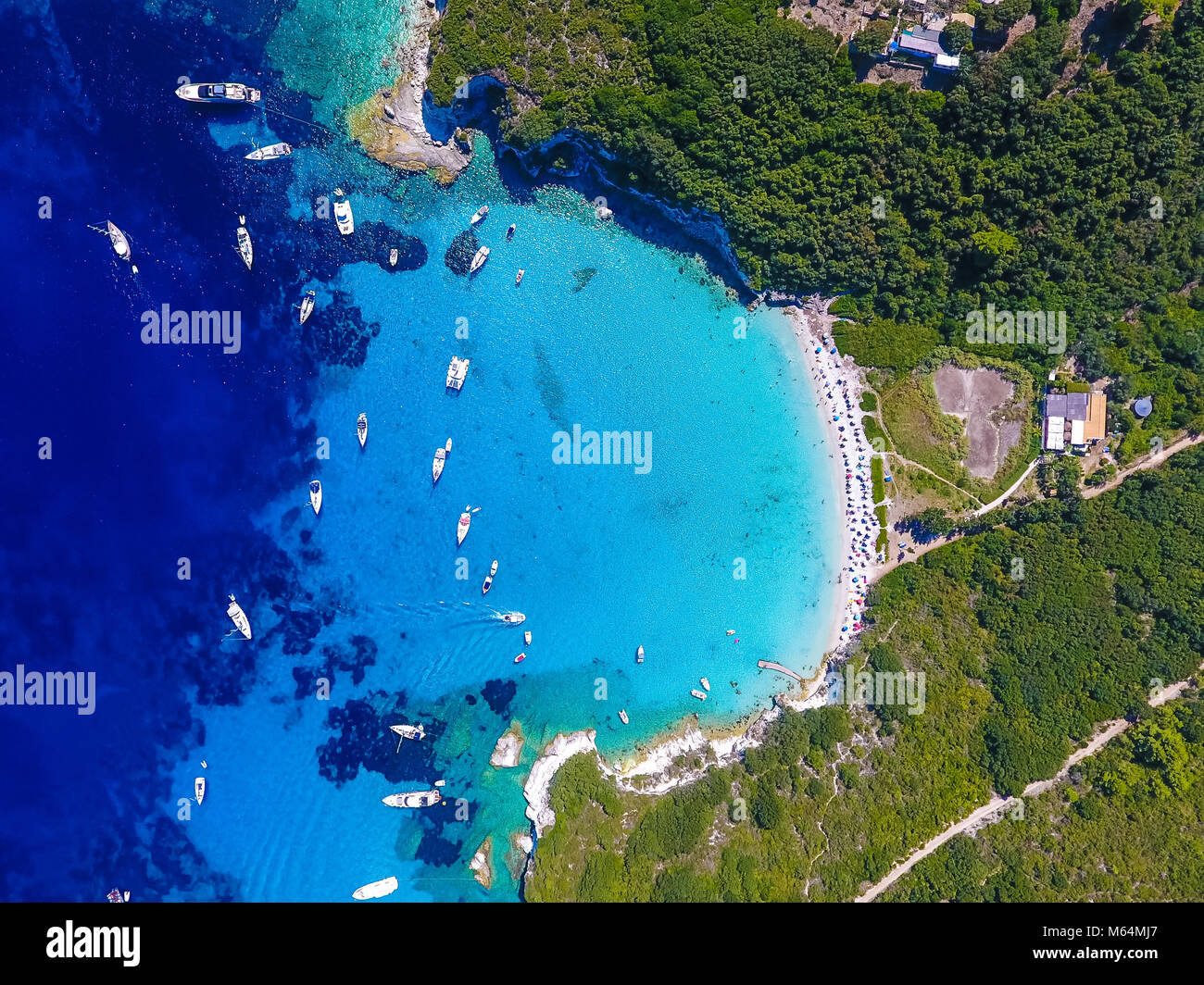 Antipaxos Island, Greece, with sandy beach, people swimming and yachts ...